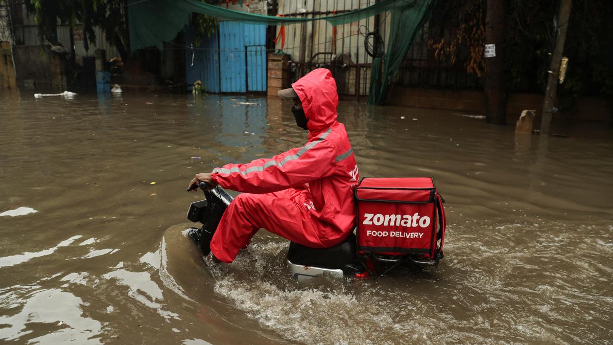 Office-goers, delivery executives brave rain - The Hindu