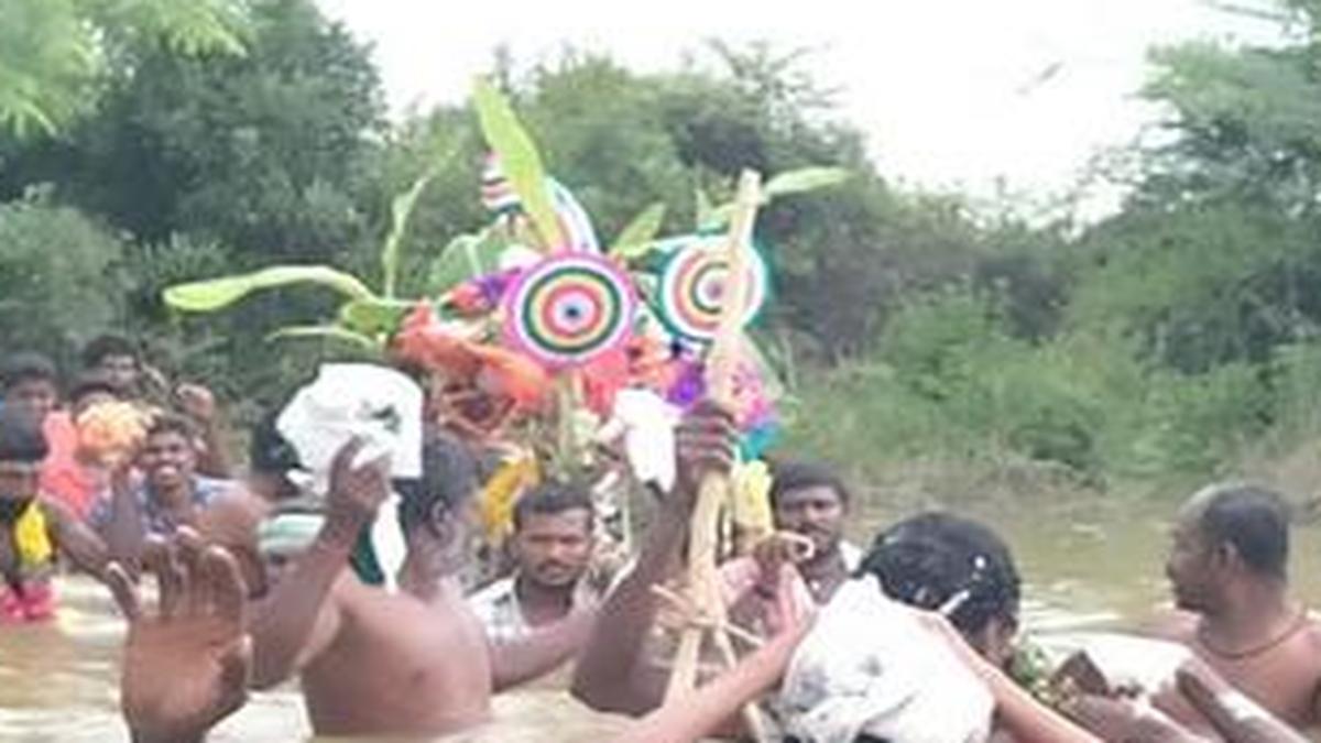 Villagers wade through channel to carry dead man to cremation ground ...